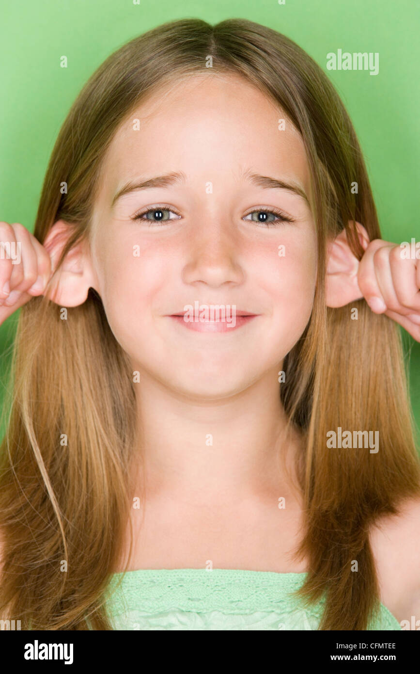 Studio shot portrait of teenage girl pulling her ears, close-up Stock ...