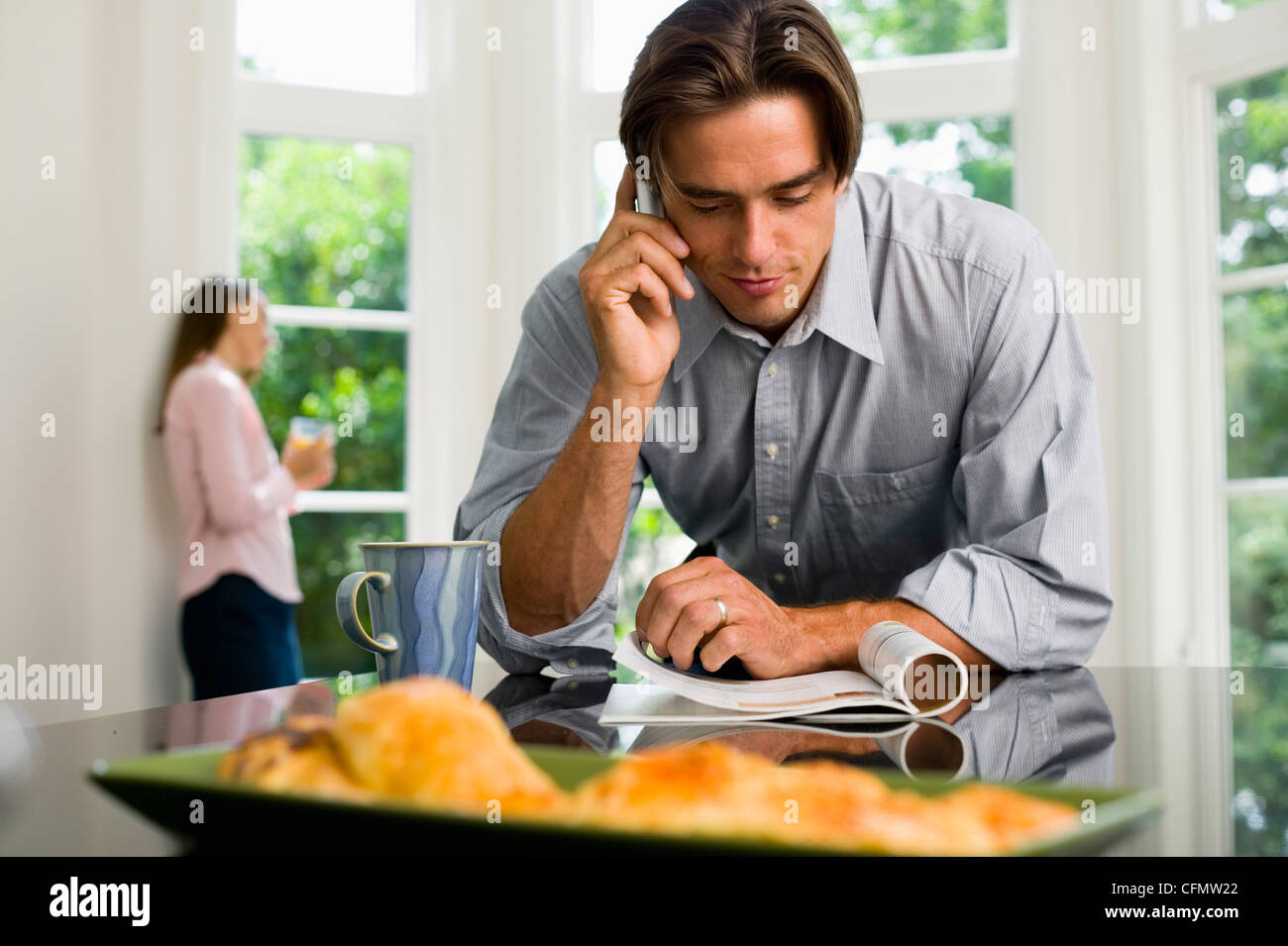 Man using Cellphone in Kitchen Stock Photo - Alamy