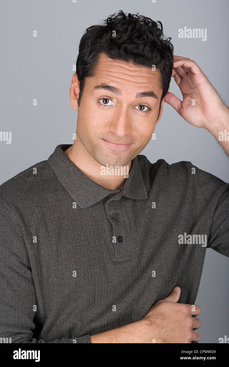 Studio shot portrait of mid adult man scratching head, head and ...