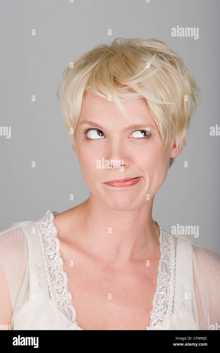 Studio shot portrait of mid adult woman blowing hair over face, close ...