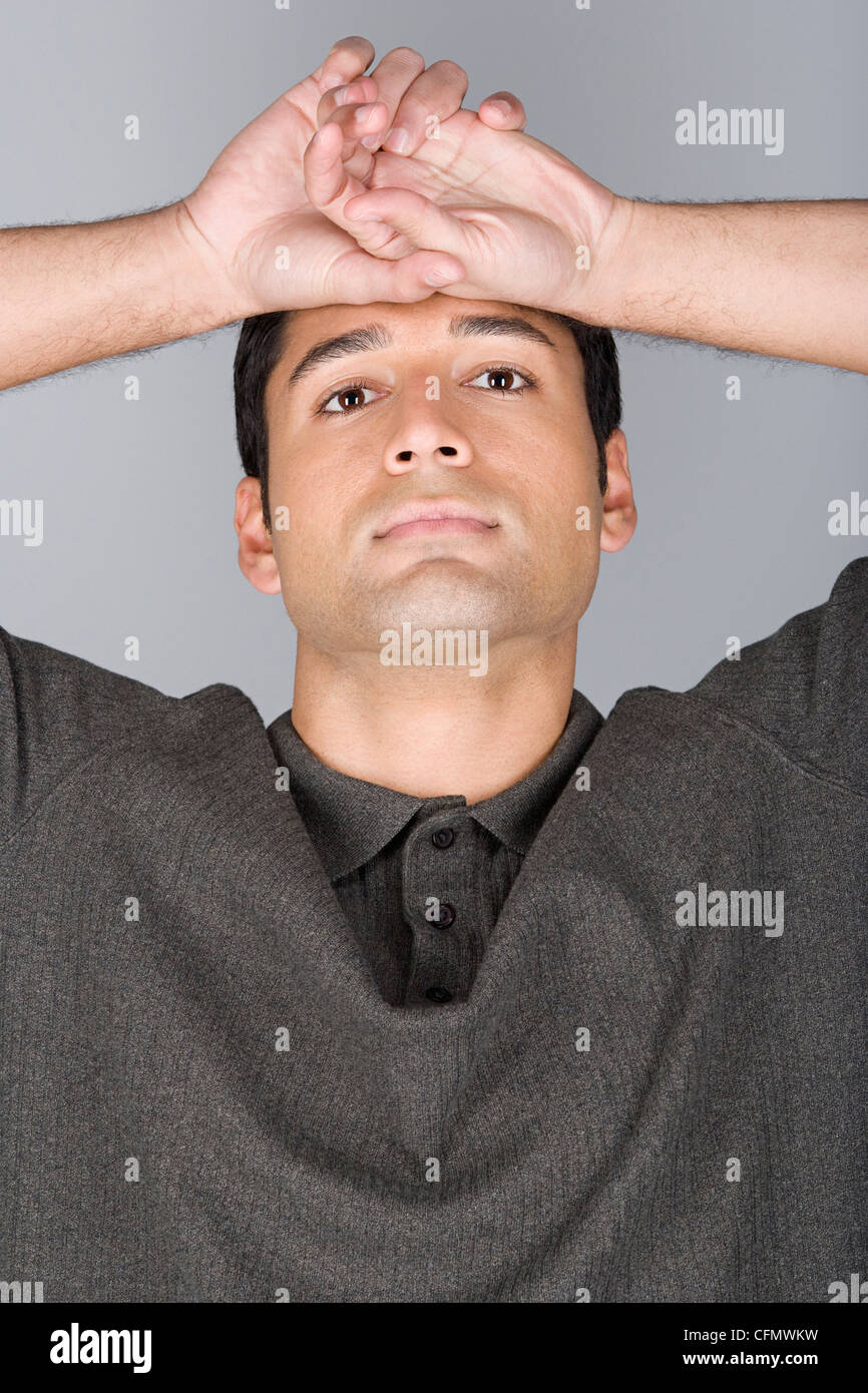 Studio shot portrait of mid adult man with arms raised, head and ...