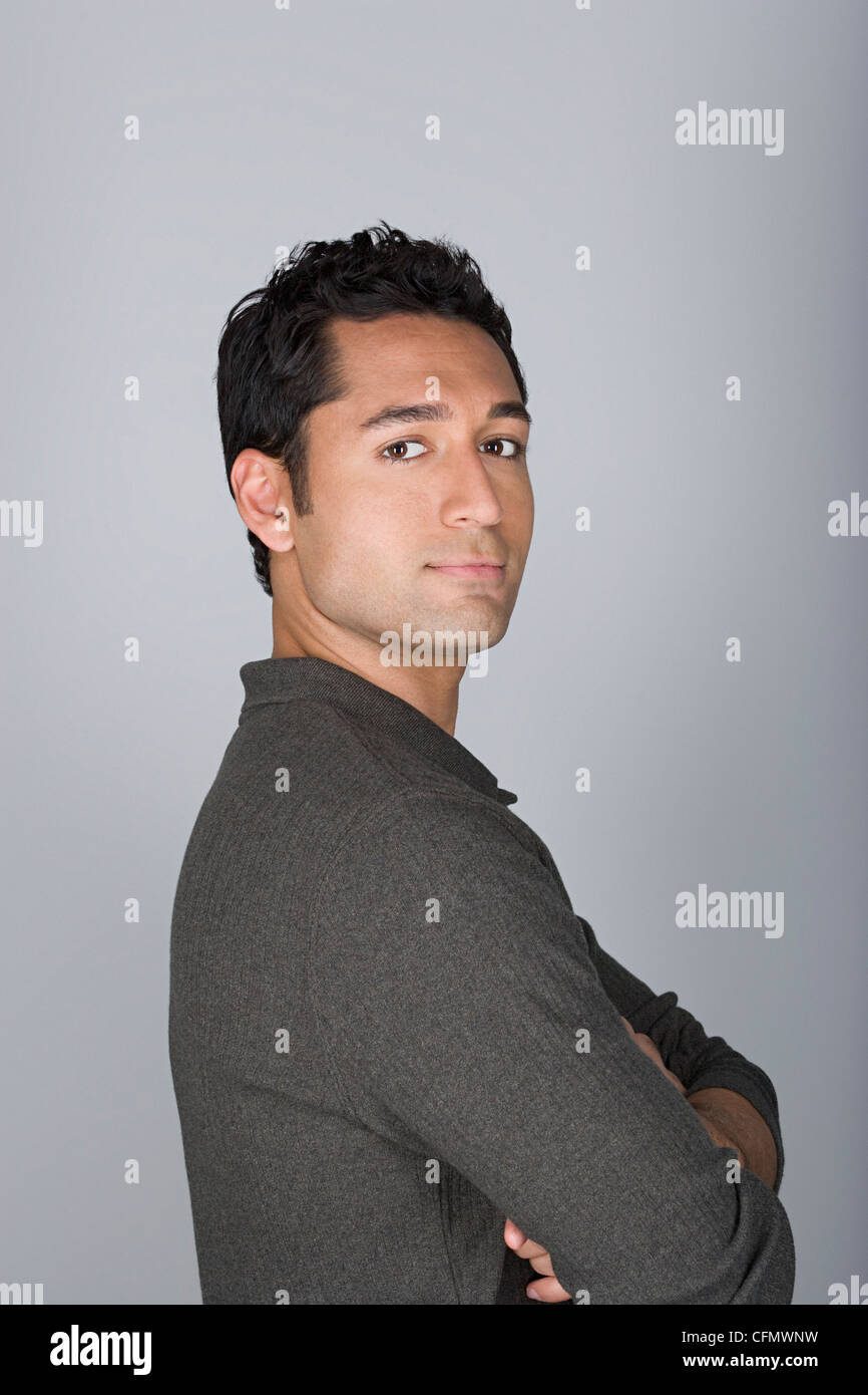 Studio shot portrait of mid adult man with arms crossed, head and ...