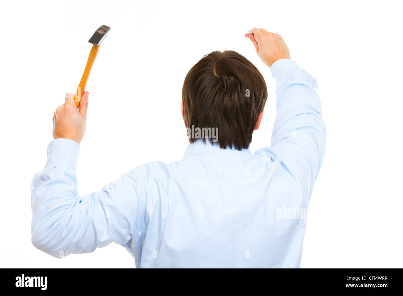 Construction worker hammering nail. Back view Stock Photo - Alamy