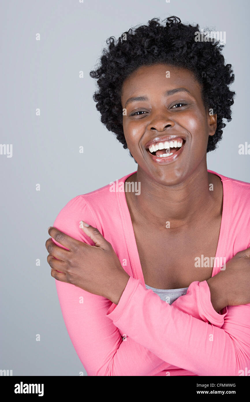 Studio shot portrait of mid adult woman with arms crossed, head and ...