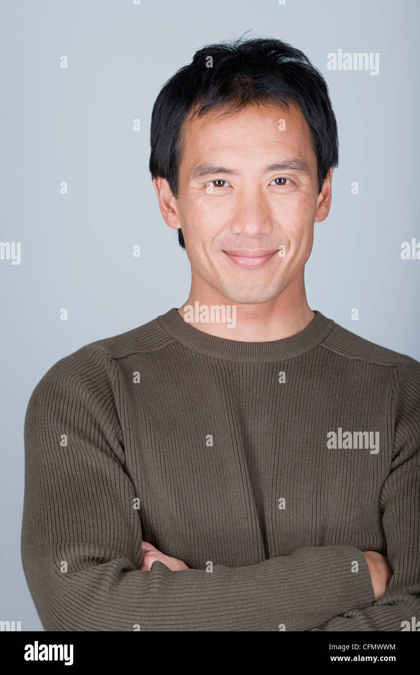 Studio shot portrait of mature man with arms crossed, head and ...