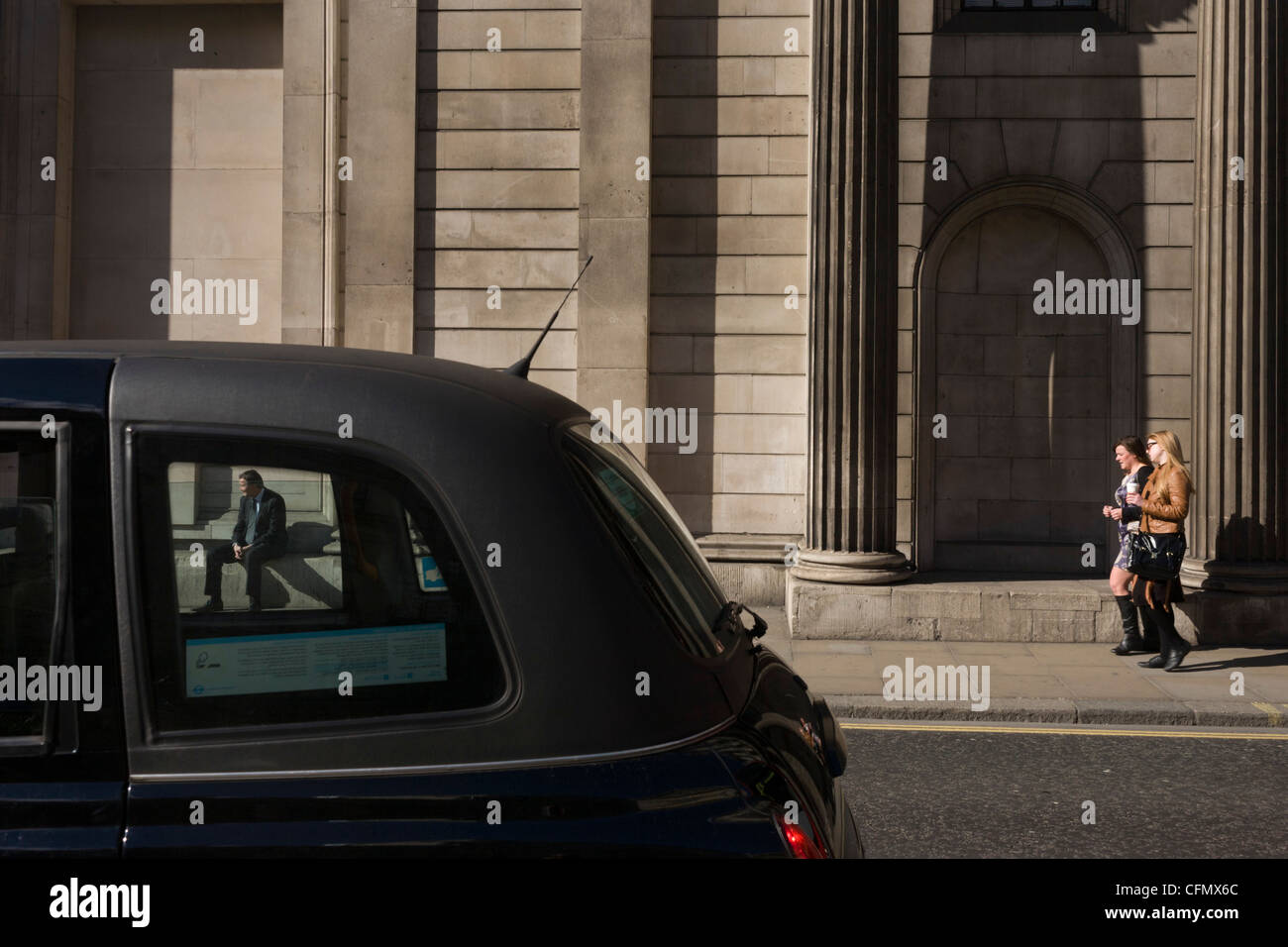 resting man seen through squared taxi cab window and approaching women ...
