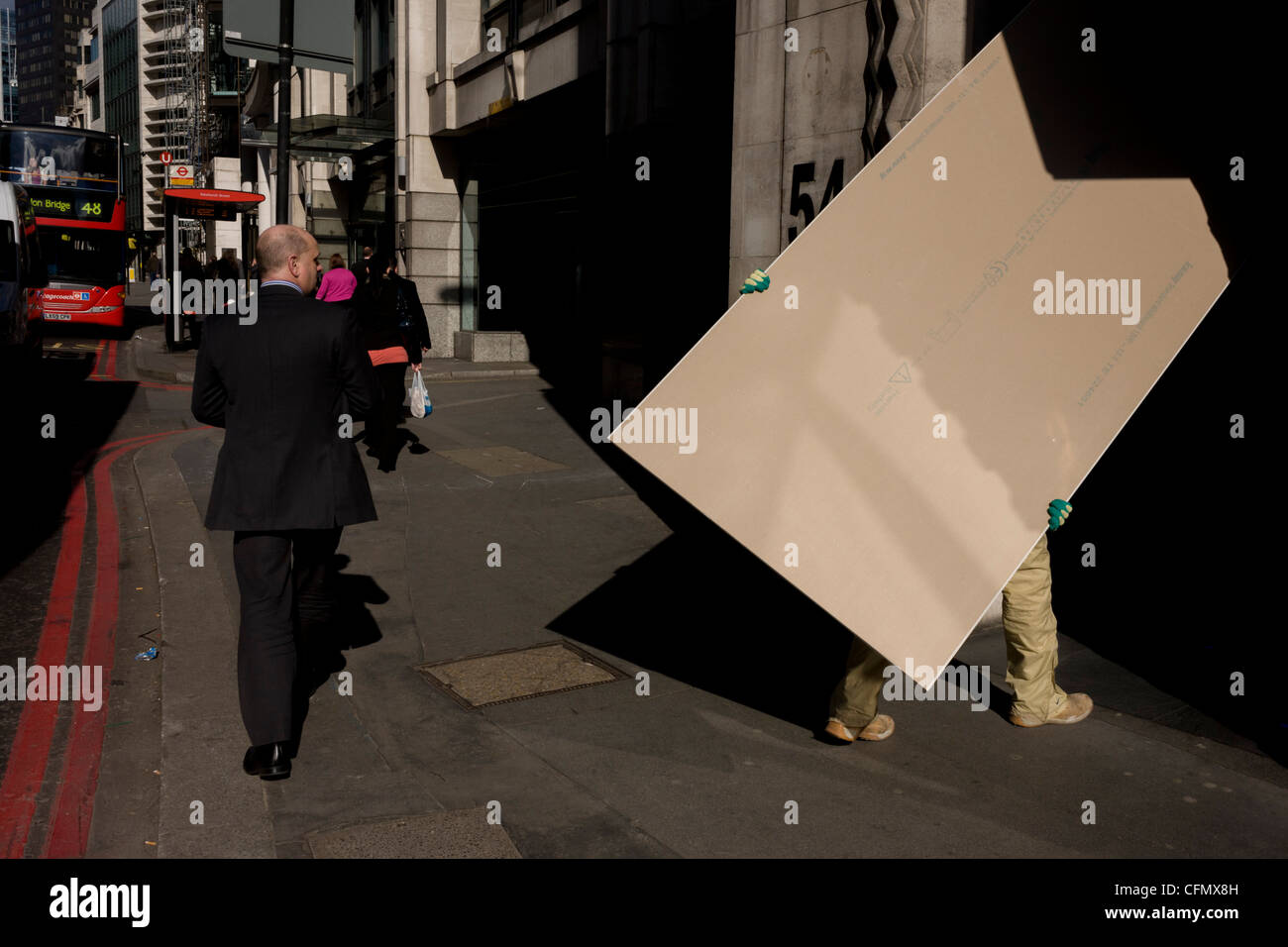 Workman delivering plaster wallboard destined for inside central London ...