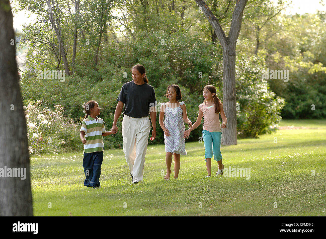 Family Walking in Park Stock Photo - Alamy
