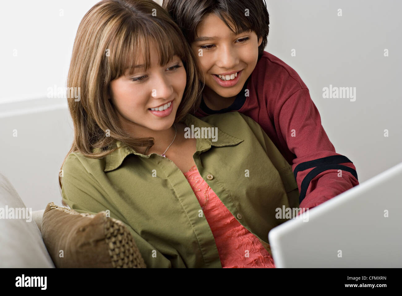 USA, California, Los Angeles, Brother and sister using laptop in living ...