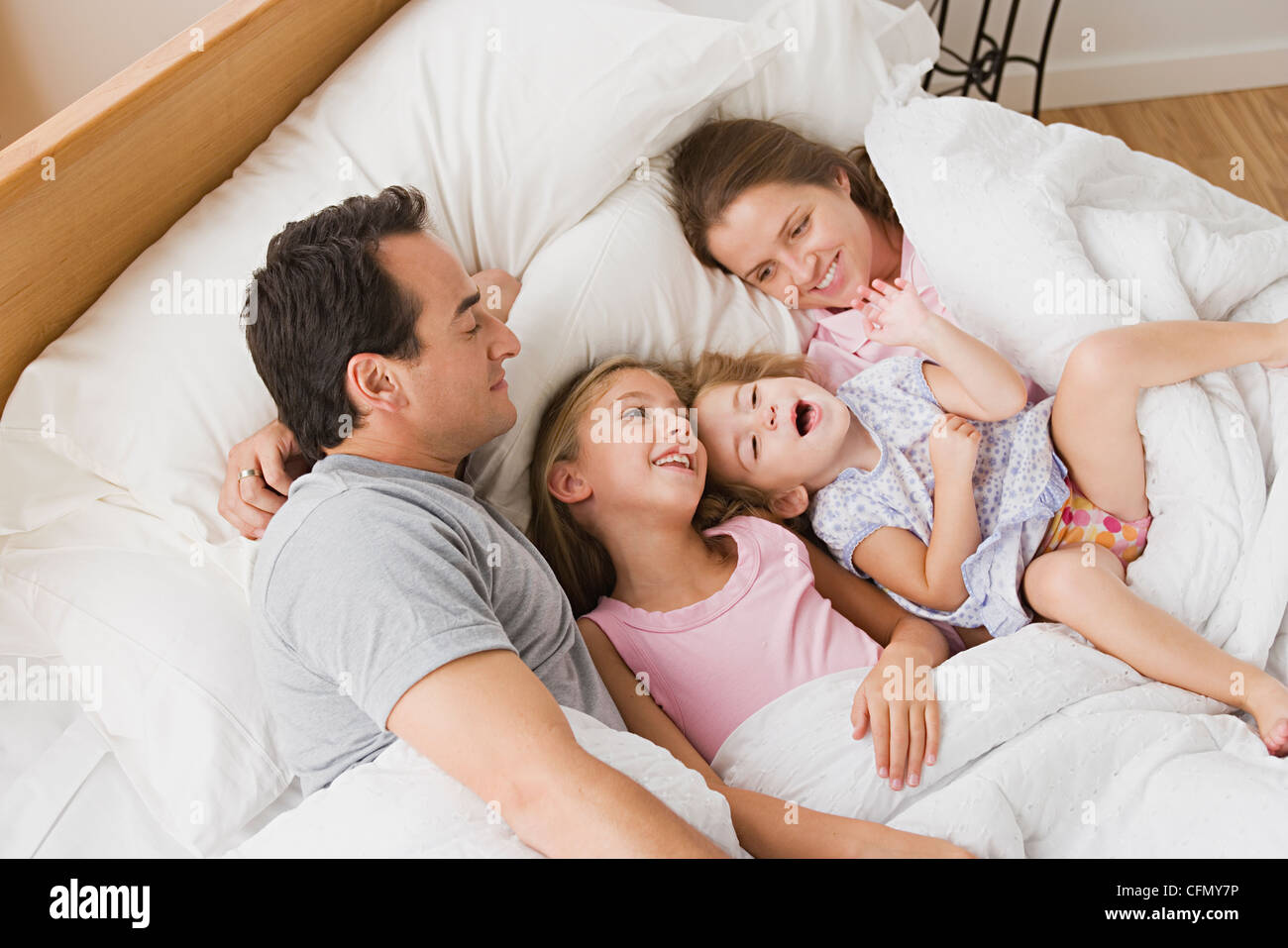 USA, California, Los Angeles, Family with two children chilling in bed ...