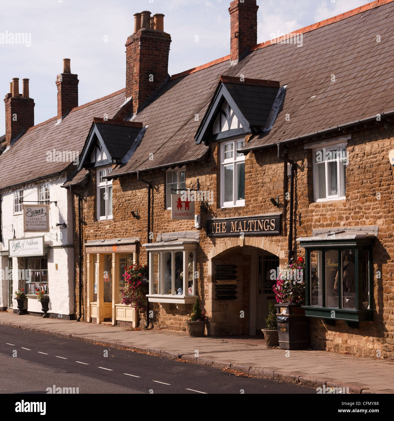 A row of traditional old shop fronts, signs and along town centre ...