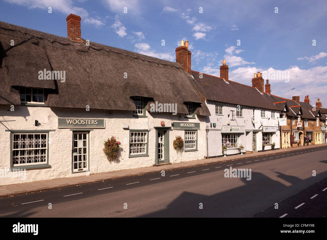 A row of traditional old shop fronts, signs and along town centre ...