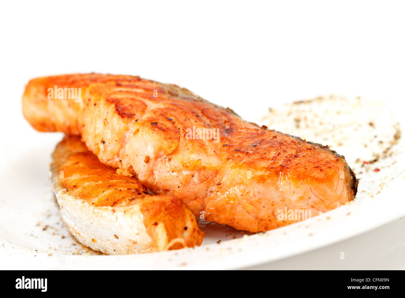 Fried salmon fillets with sauce on white plate Stock Photo - Alamy