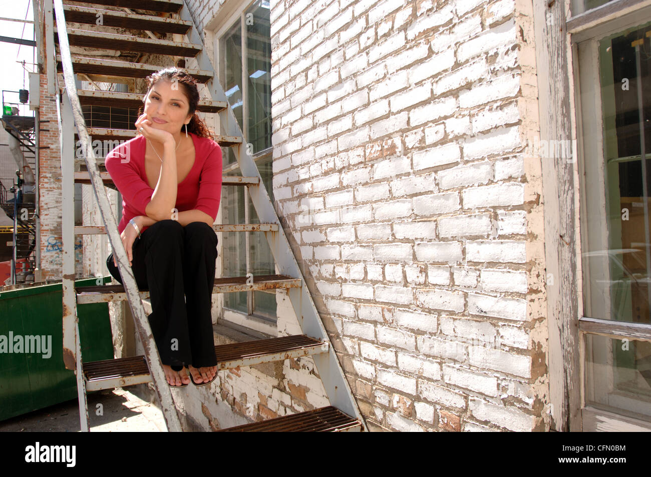 Woman Sitting on Fire Escape Stock Photo - Alamy