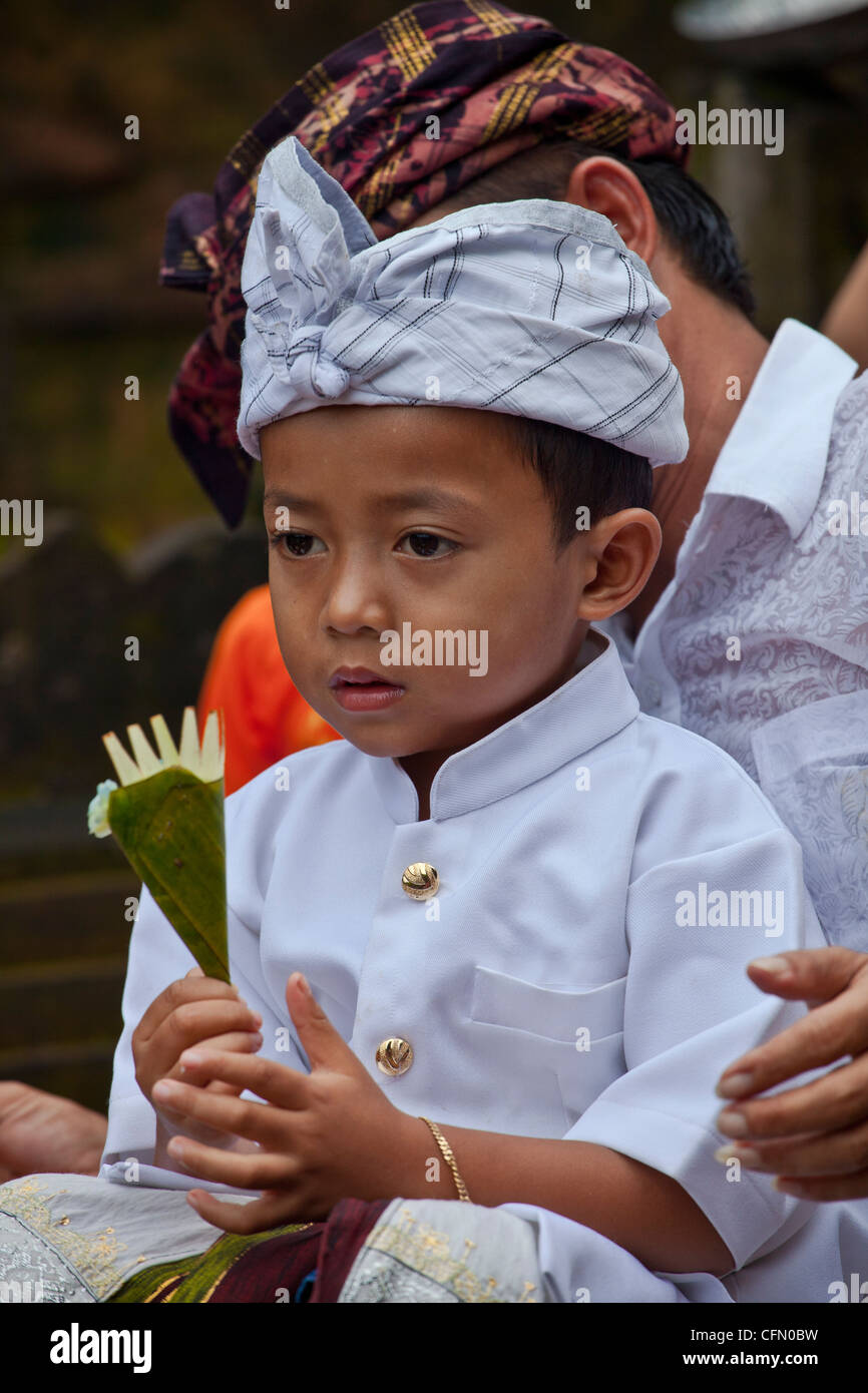 Young boy in traditional clothes at a religious ceremony in Bali, South ...