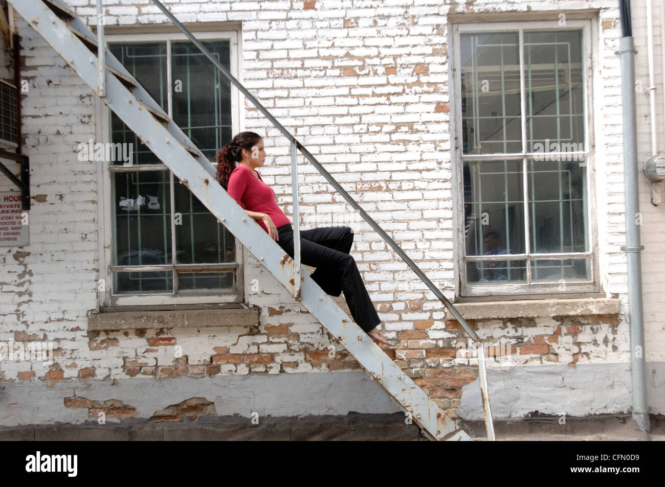 Woman Sitting on Fire Escape Stock Photo - Alamy