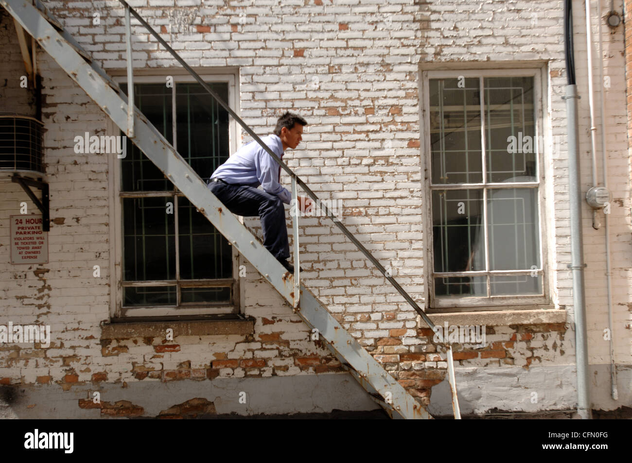Man Sitting on Fire Escape Stock Photo - Alamy
