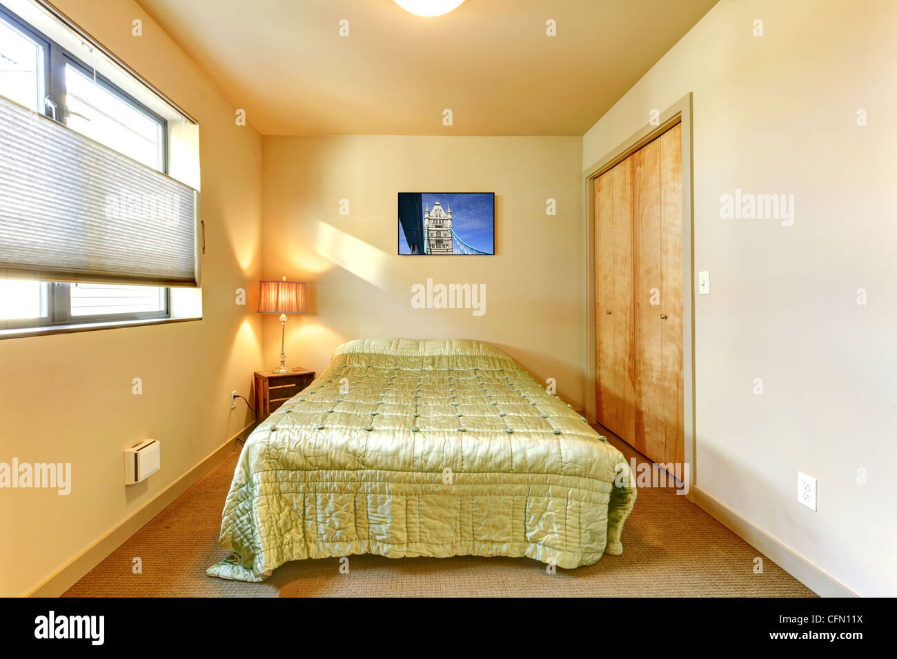 Small yellow guest bedroom interior with green bed Stock Photo - Alamy