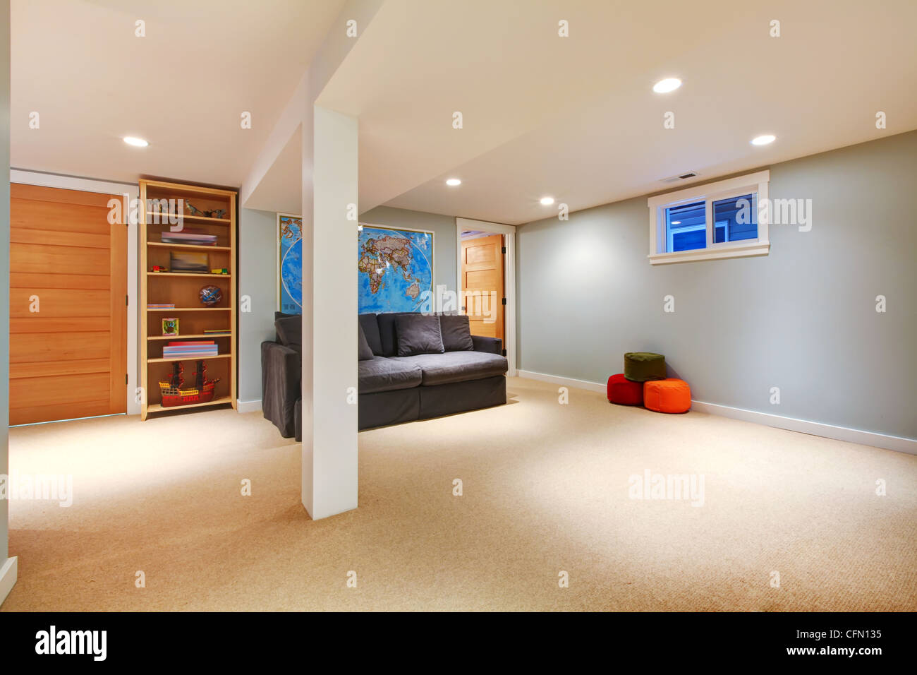 Basement blue room with sofa and book shelve Stock Photo - Alamy