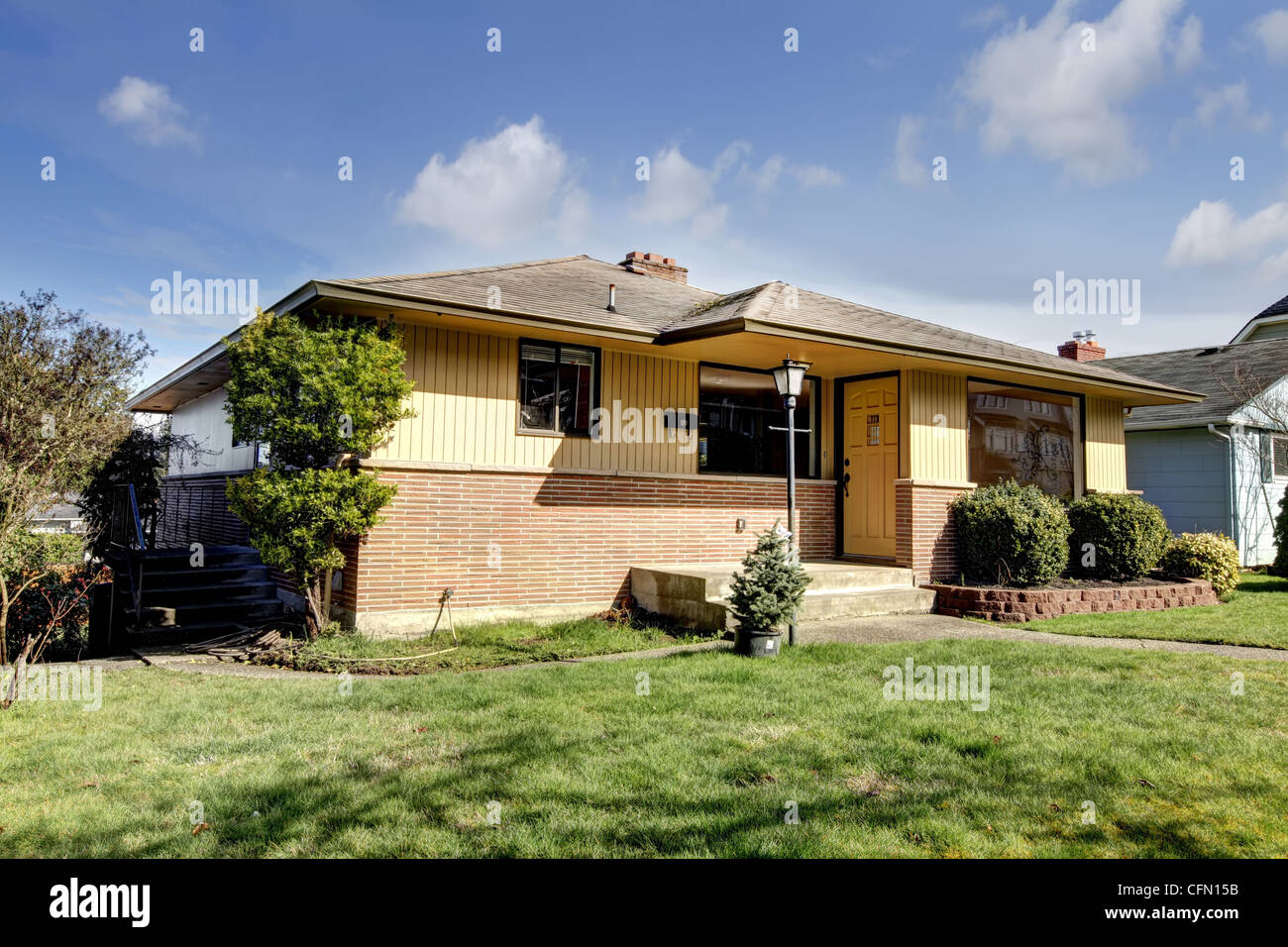 Yellow brick American rambler exterior with front wood door Stock Photo ...
