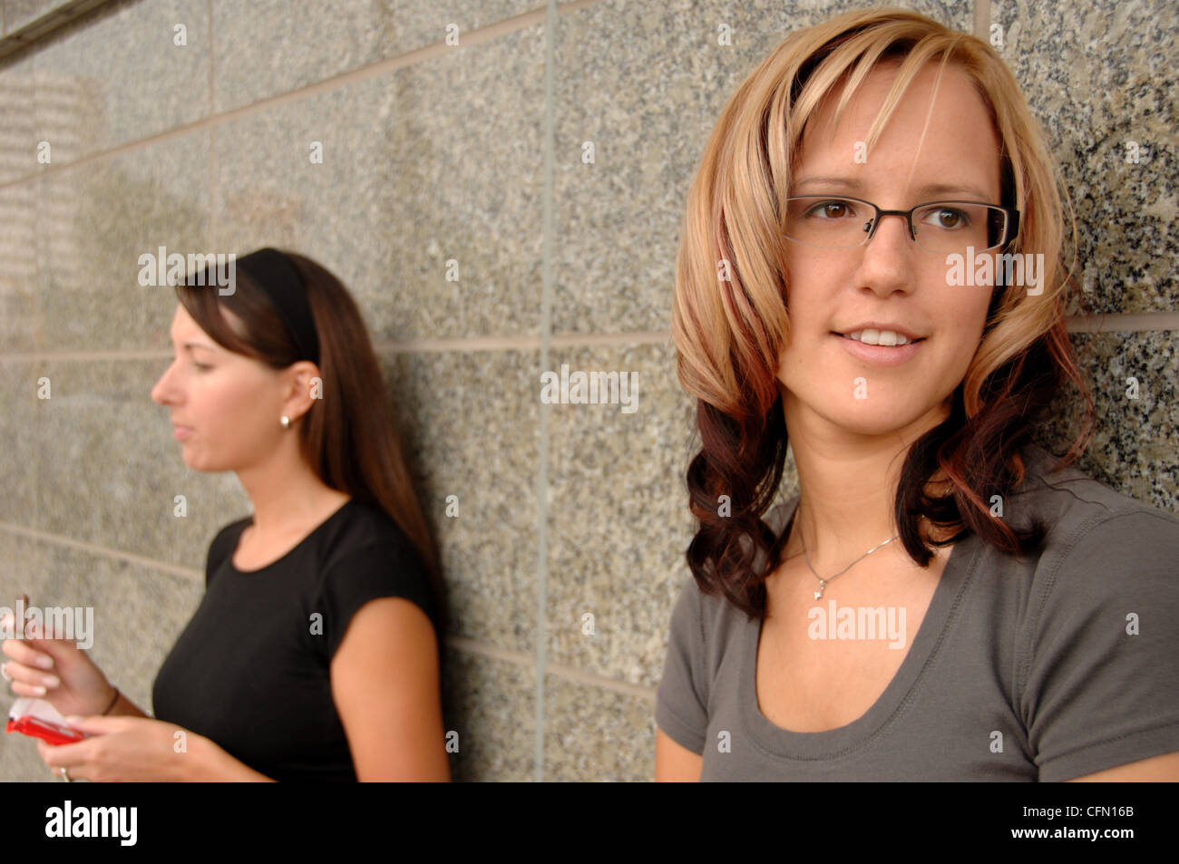 Women Leaning on Wall Outside Stock Photo - Alamy