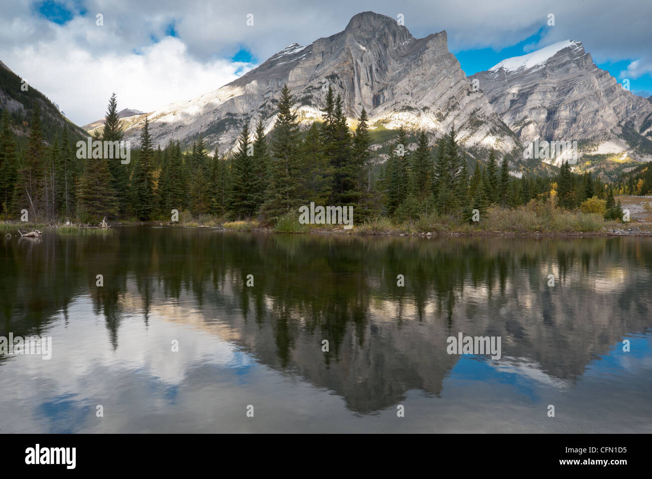 Mount Kidd is reflected in a small pond along highway 40 in Alberta's ...