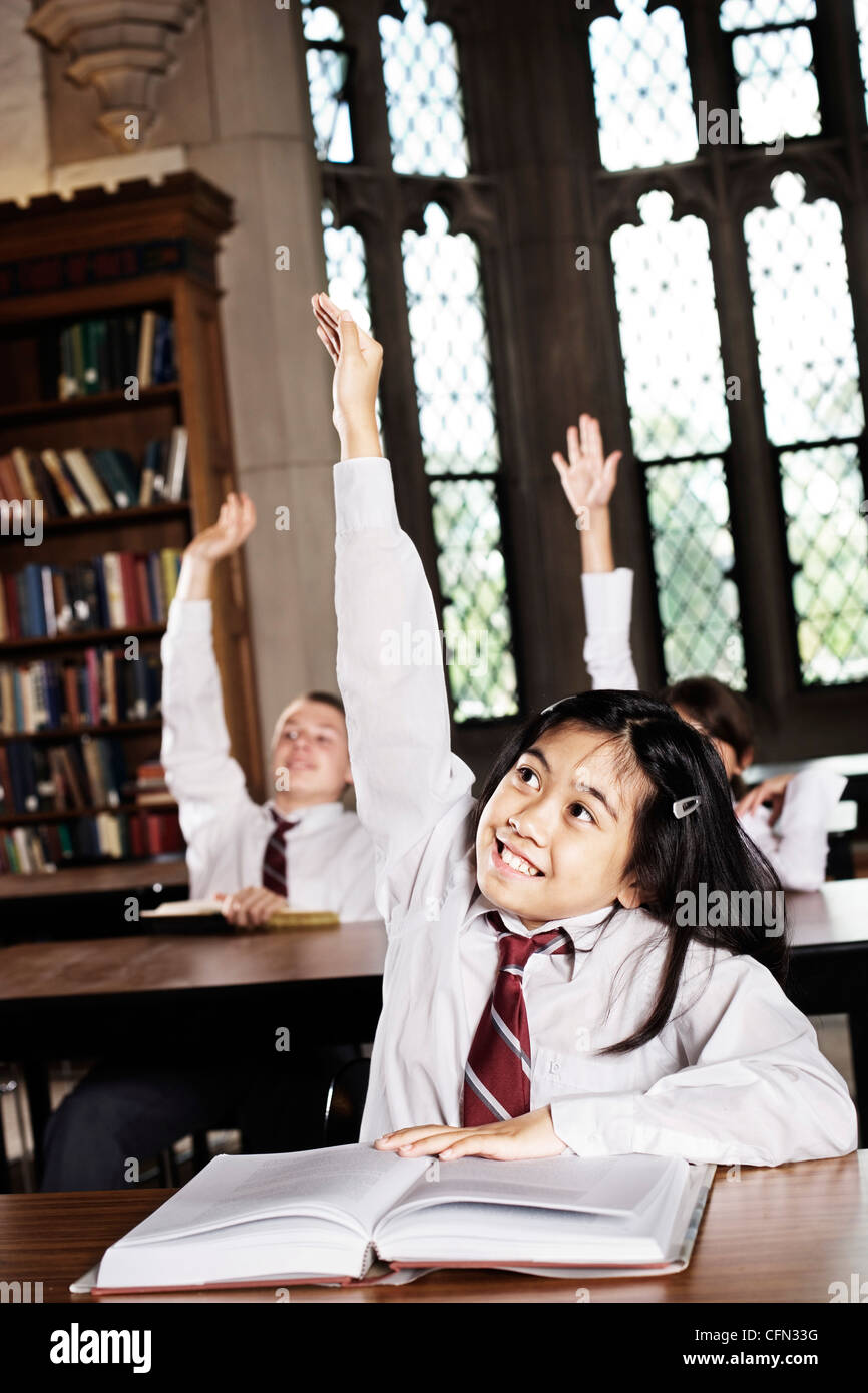 Students with Hands Up in Class Stock Photo - Alamy