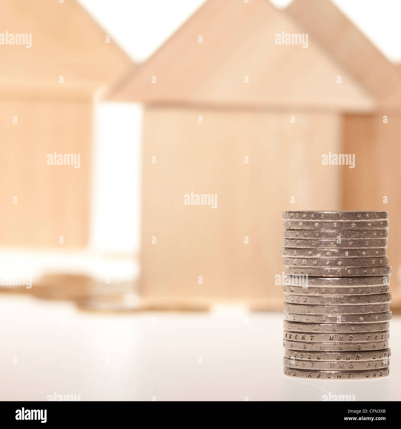 Stack of coins with residential structure isolated on white background ...