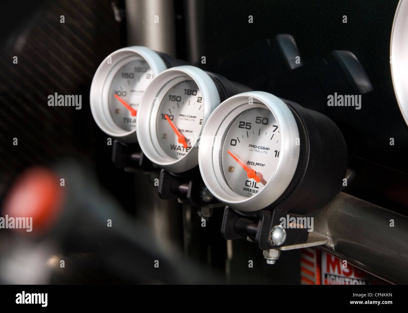 3 gauges on a hot rod dash board white face orange needle Stock Photo ...