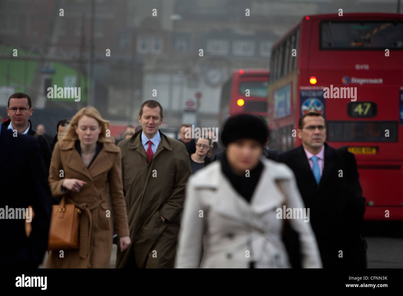 Commuters and busy traffic crossing London Bridge on a smoggy morning ...