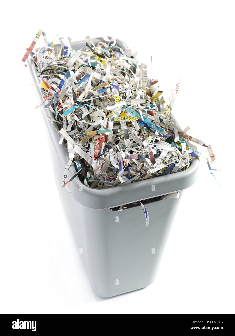Paper cuttings in gray plastic disposal bin - over white background ...