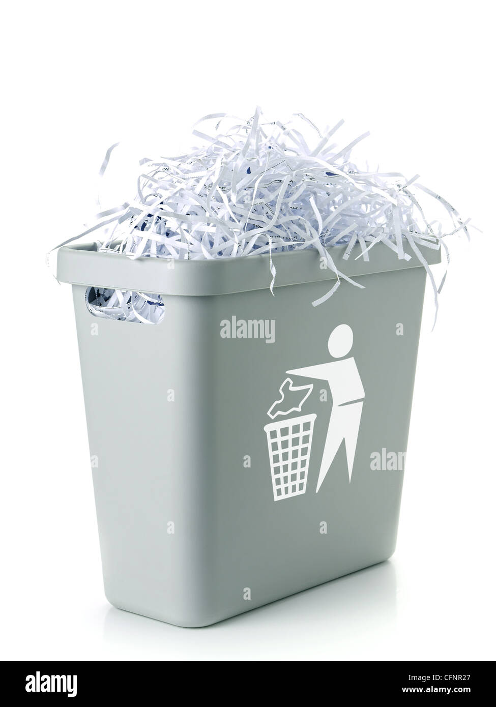 Paper cuttings in gray plastic disposal bin with white paper trash ...