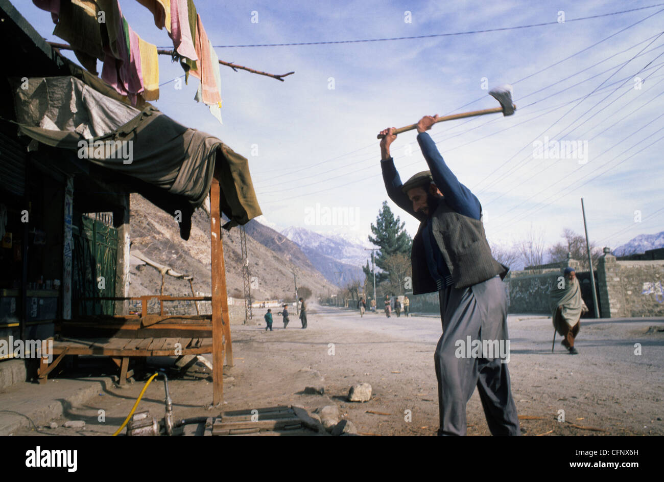 Man cutting firewood in the streets of Gilgit, Hunza Valley, Pakistan ...