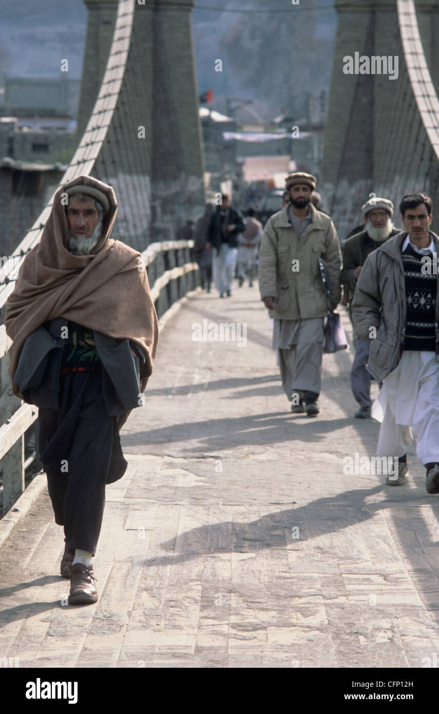 Men crossing the suspension bridge in Gilgit, Hunza Valley in, Pakistan ...