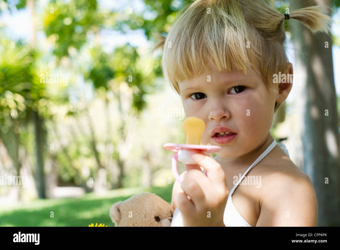 Little girl holding pacifier Stock Photo - Alamy