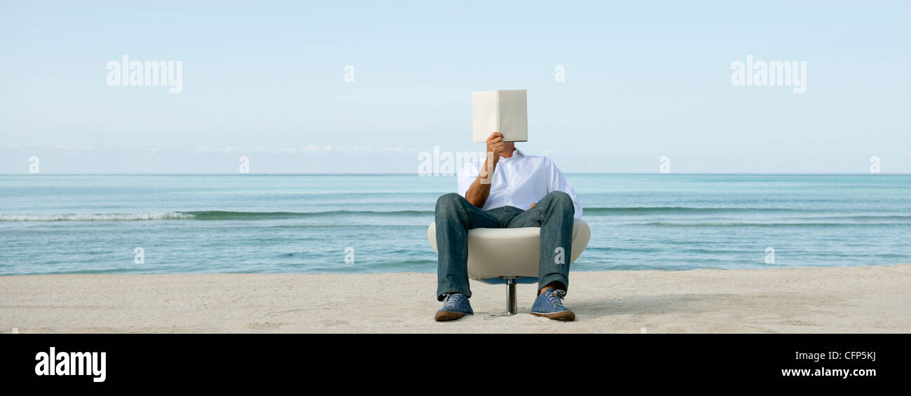 Man reading book at the beach Stock Photo - Alamy