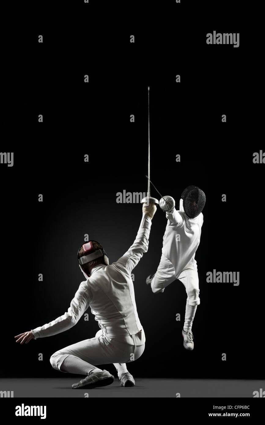 Fencers fencing, one fencer jumping in air Stock Photo - Alamy