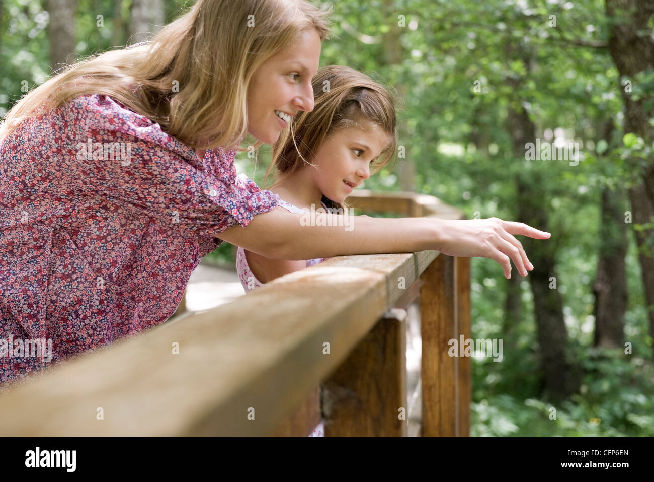 Mother and young daughter looking over railing together Stock Photo - Alamy