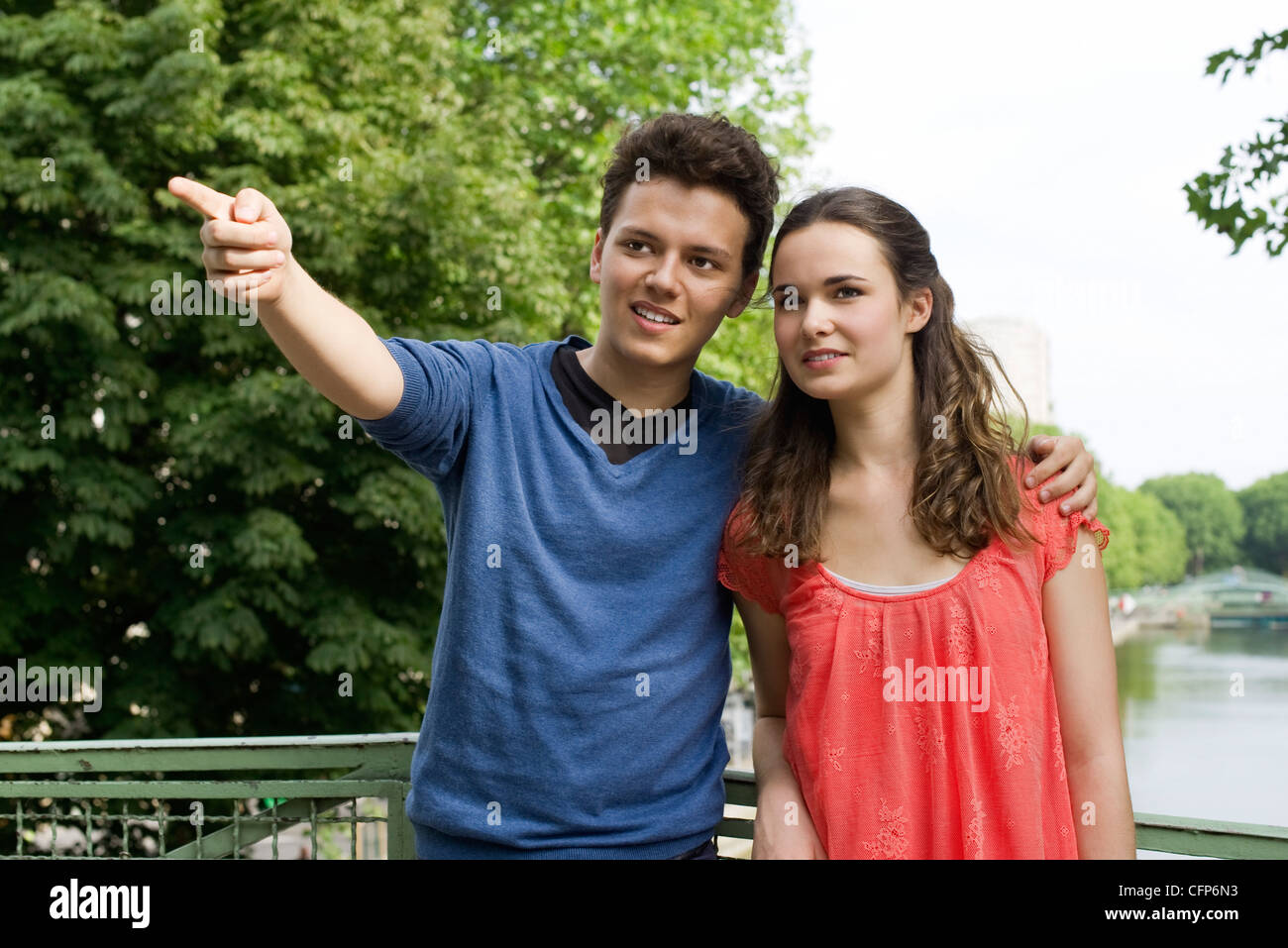 Young couple outdoors, young man pointing into distance, portrait Stock ...