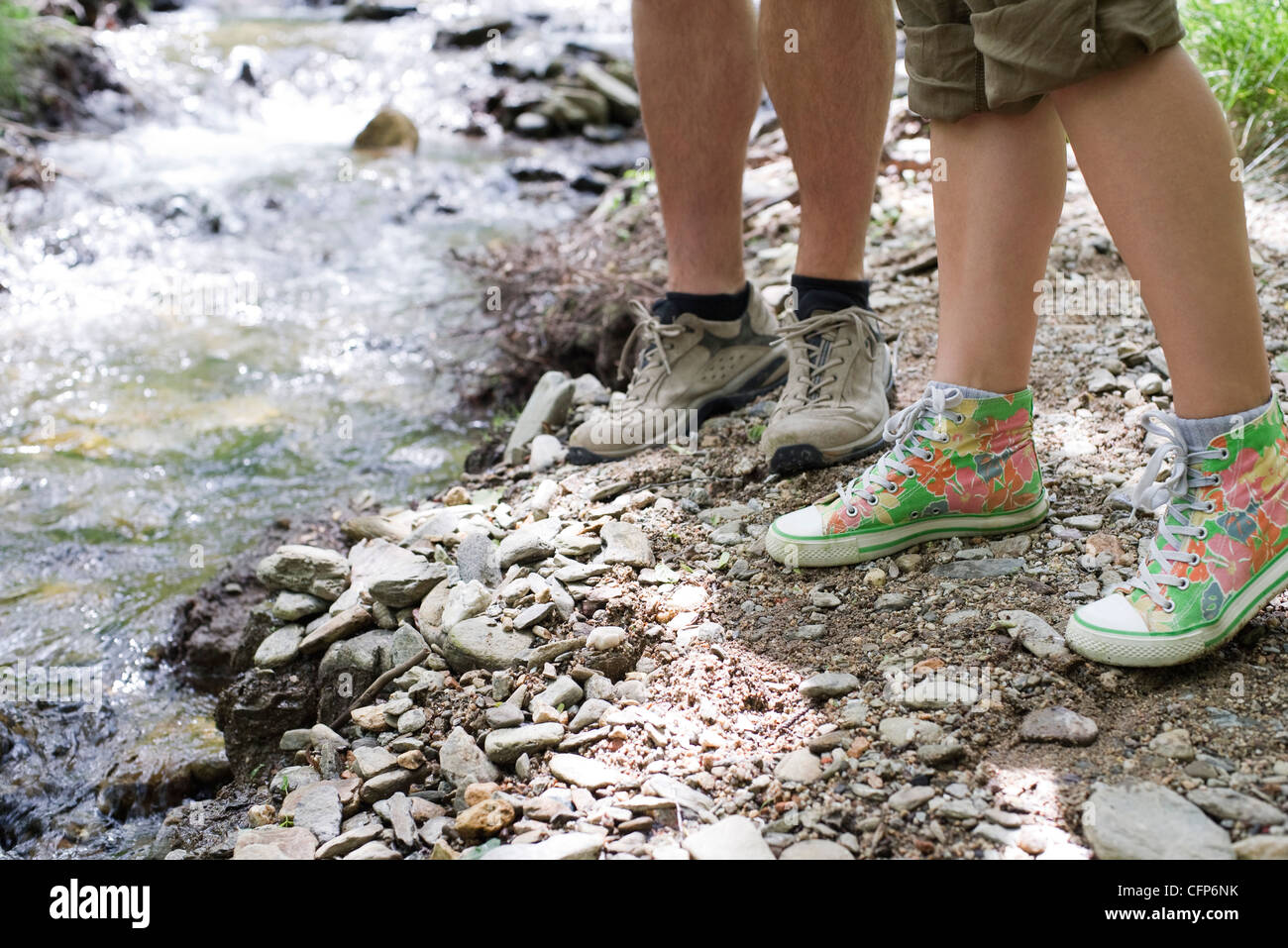 Man and woman standing by stream, low section Stock Photo - Alamy