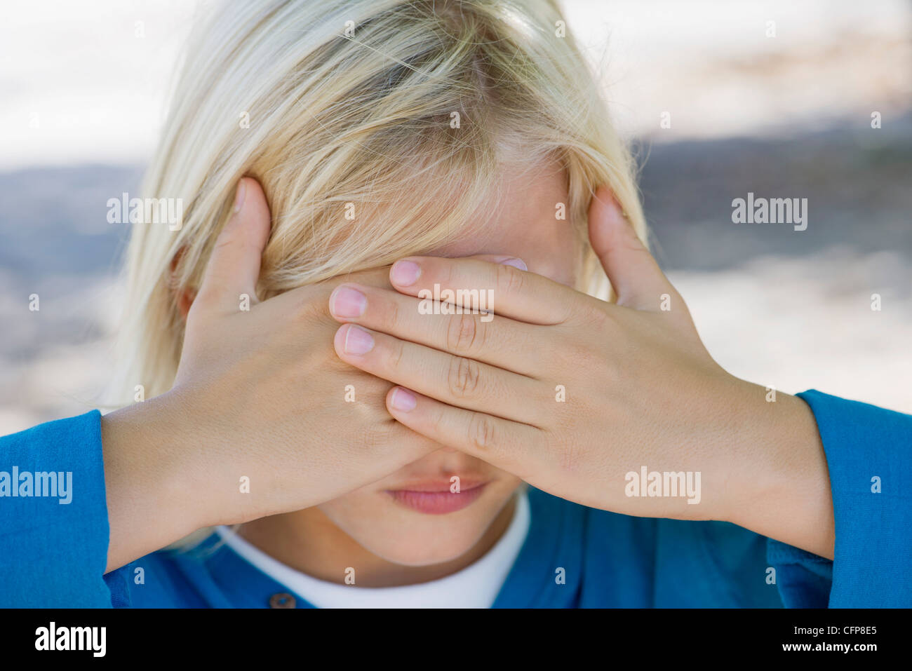 Boy with hands covering eyes Stock Photo - Alamy