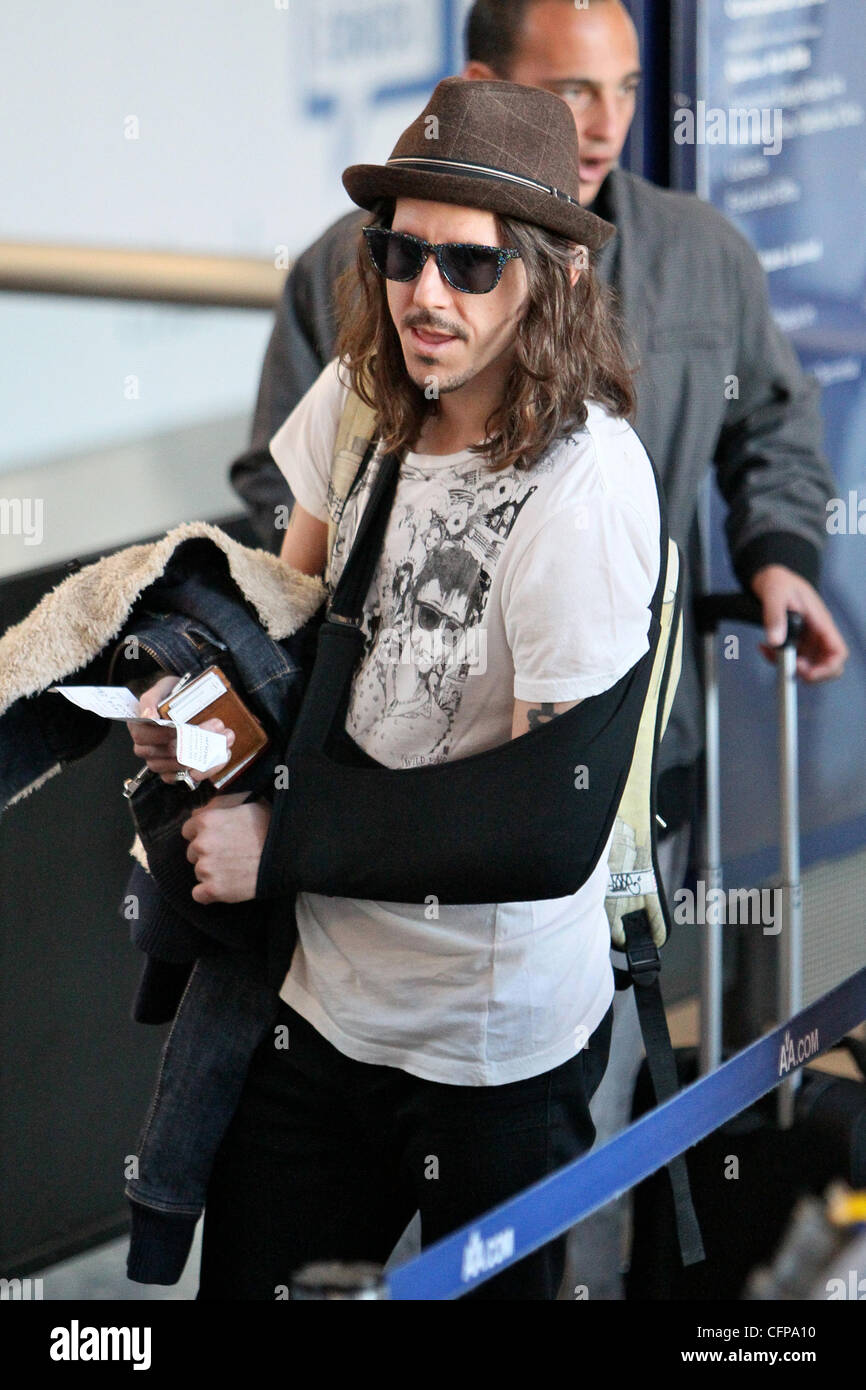Cisco Adler arrives at LAX wearing a cast on his left arm, which he ...