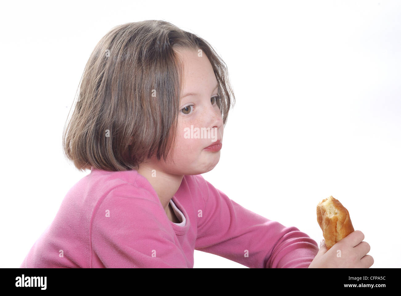 A young girl eating a bun Stock Photo - Alamy