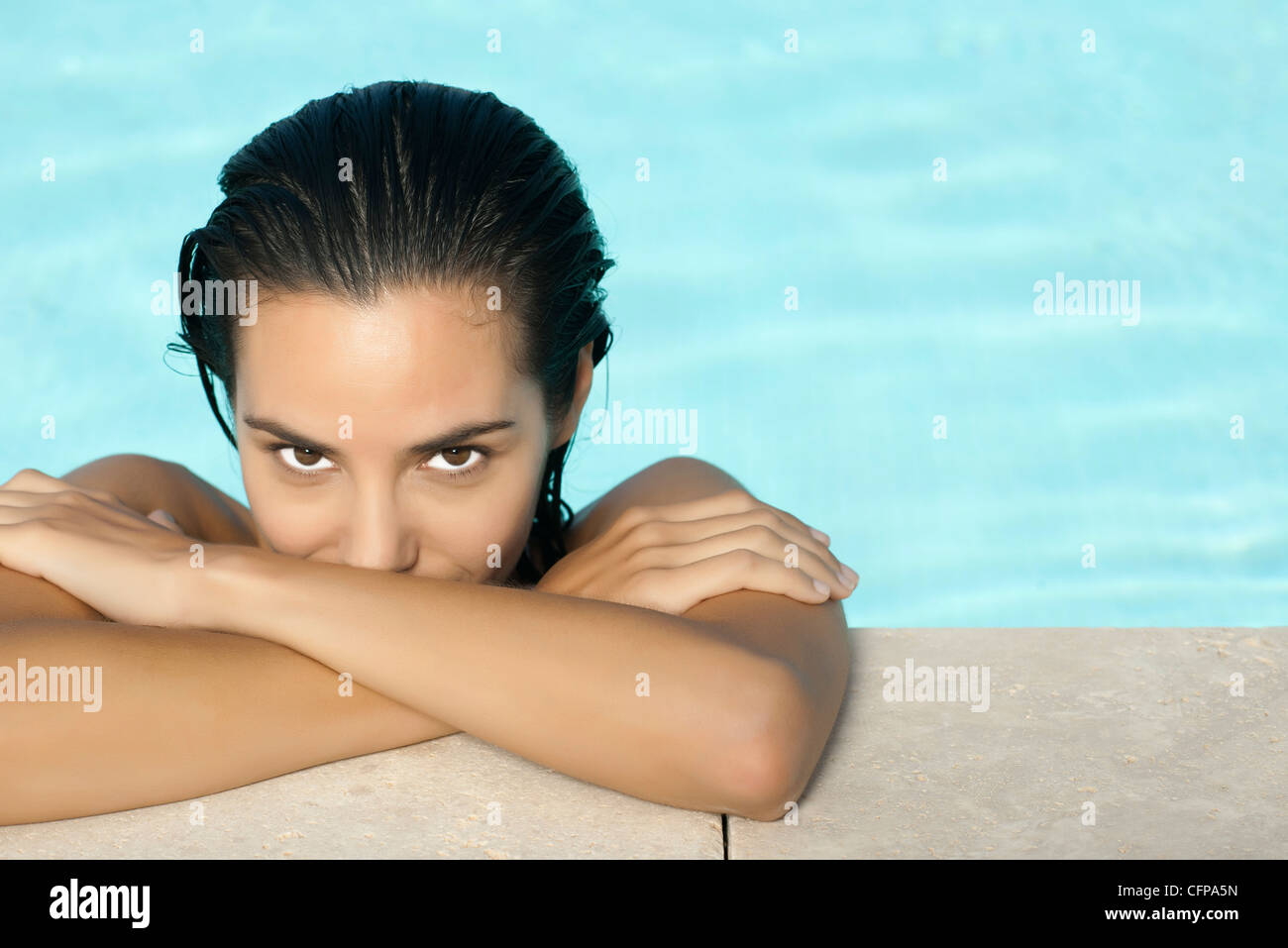 Woman in swimming pool, resting head on arms, portrait Stock Photo - Alamy