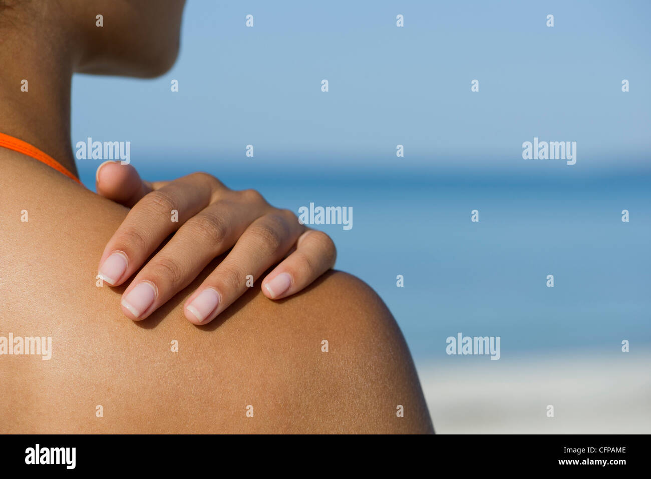 Woman touching bare shoulder at the beach, cropped Stock Photo - Alamy