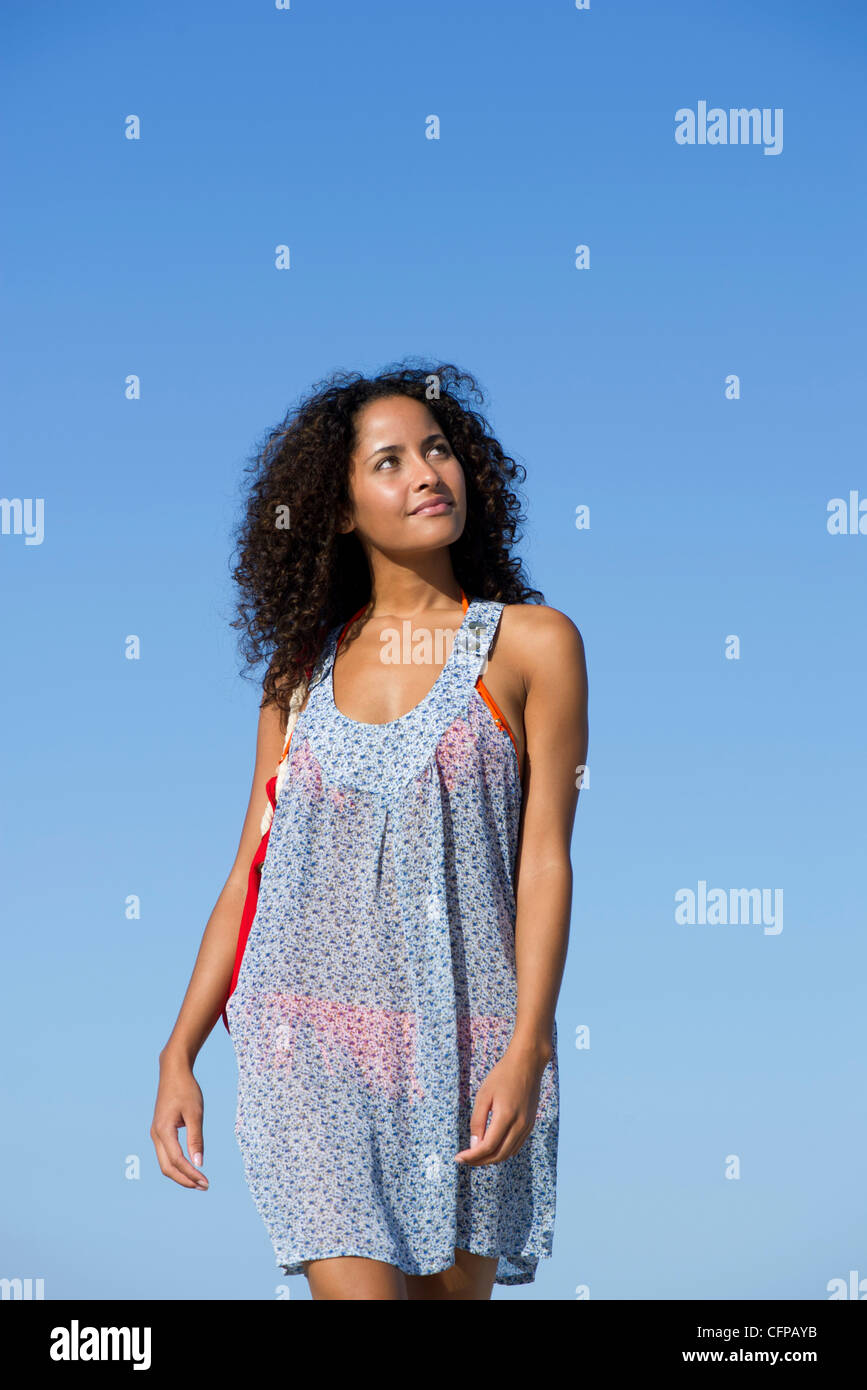 Woman in sundress walking outdoors, looking up and smiling Stock Photo ...