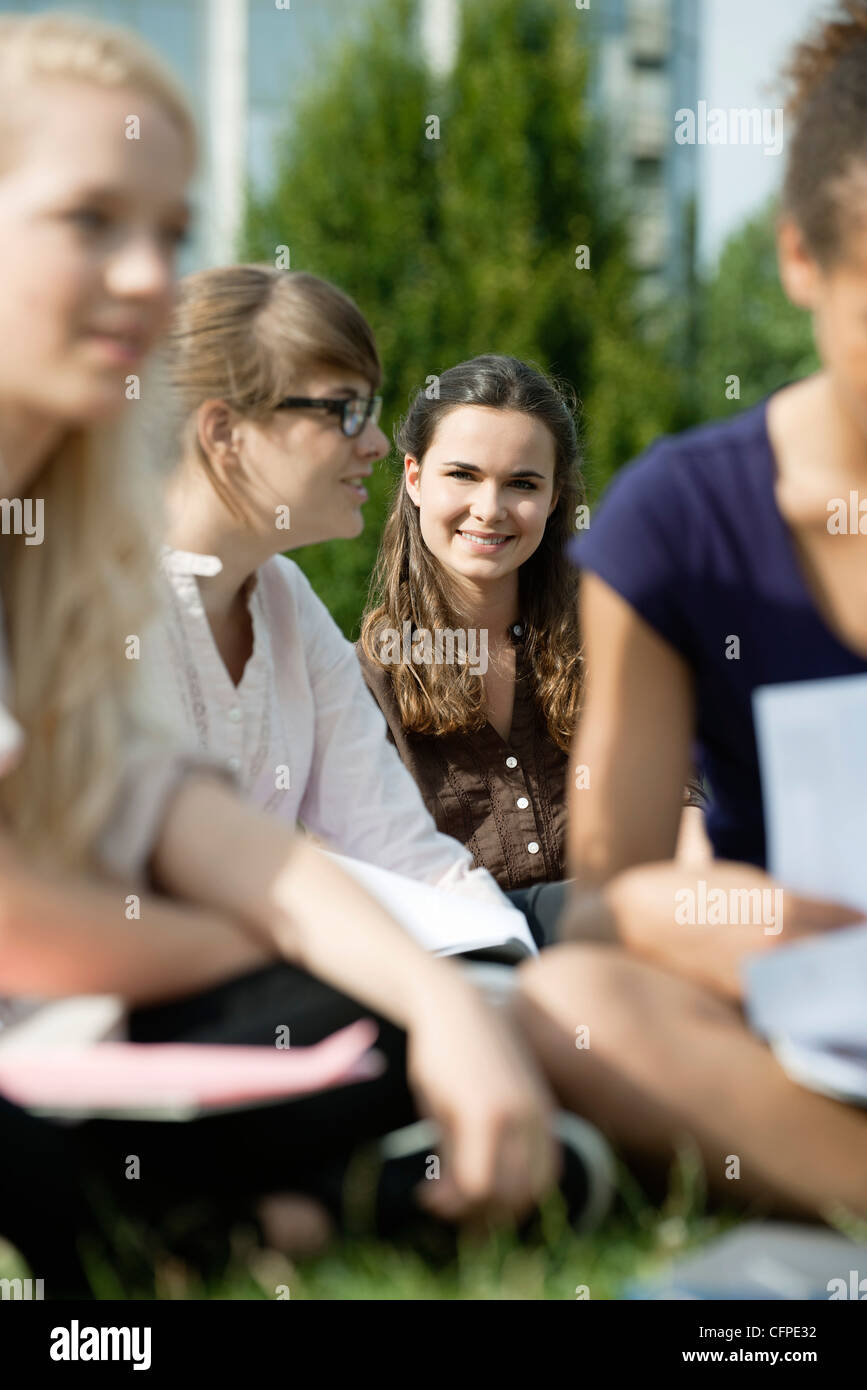 Young woman hanging out with friends outdoors, focus on woman in ...
