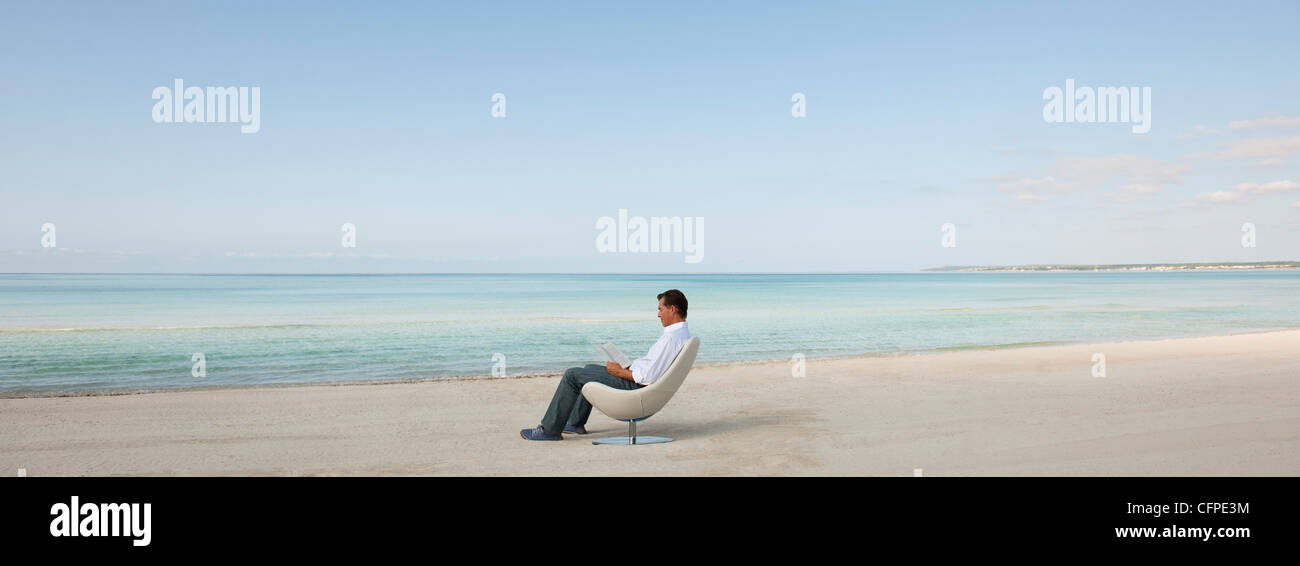 Man reading book at the beach Stock Photo - Alamy