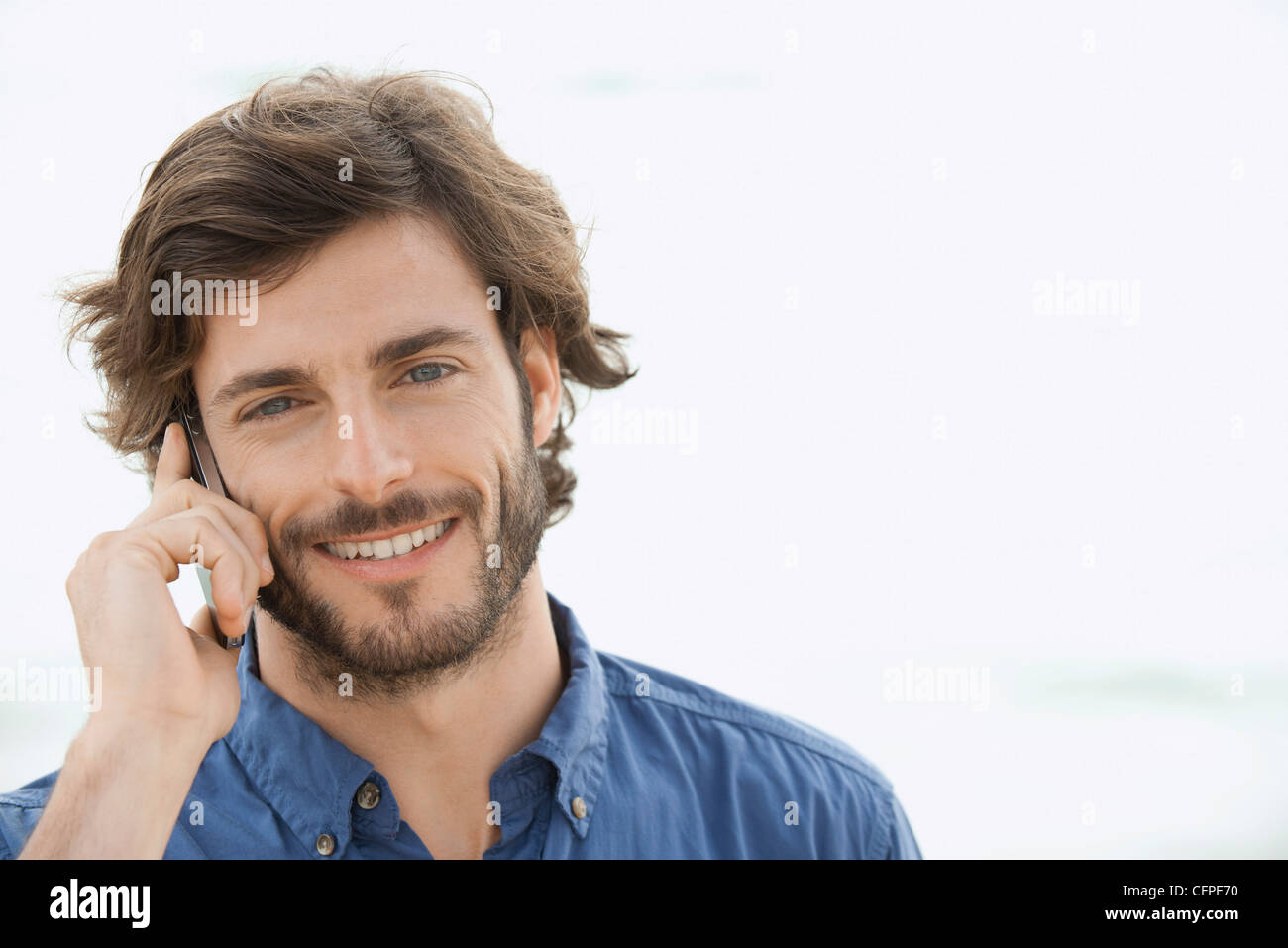 Man using cell phone outdoors, smiling, portrait Stock Photo - Alamy