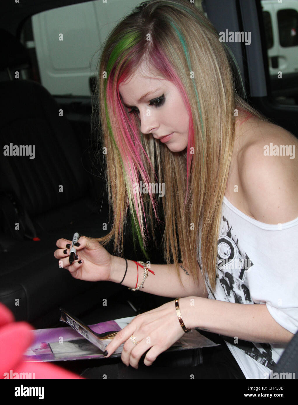 Singer Avril Lavigne signs autographs for fans as she leaves the Hotel ...